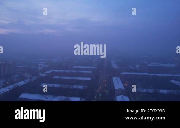 Dawn over the city in fog and smog. Mountain view. A light haze hangs ...