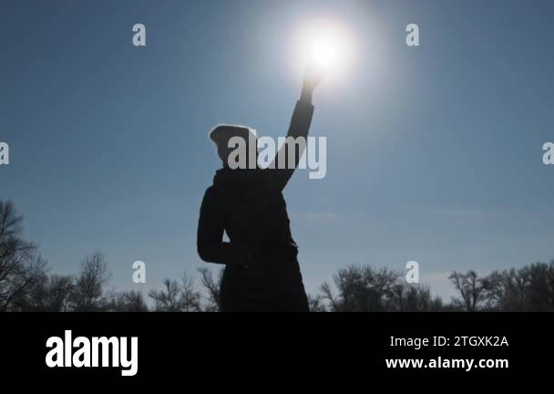 Woman tries to catch a mobile signal by holding up her smartphone ...