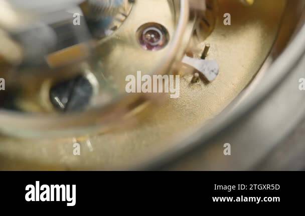 Moving gold gears inside working pocket watch mechanism. Working clock ...