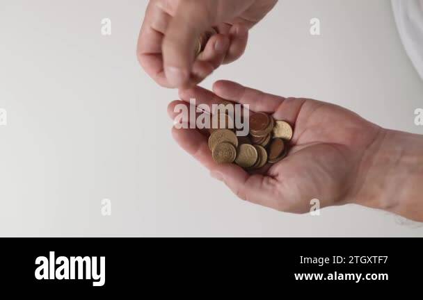 A poor man counting coins in the palm of his hand. An unrecognizable ...