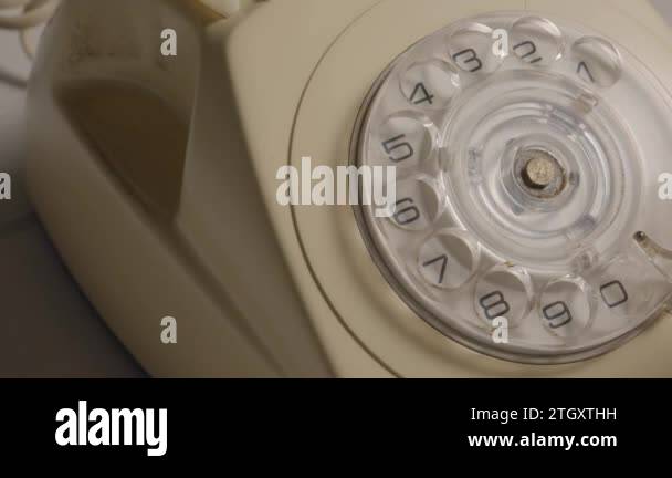 A mans hand removing the handset and rotating the dialer with his ...