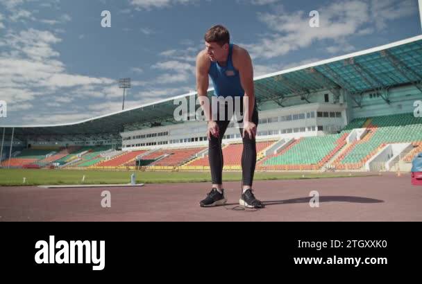 Athlete with jumping rope bending forward and breathing during break ...