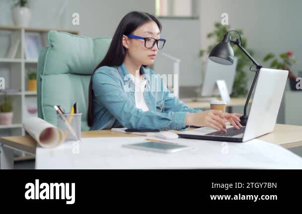 young creative asian woman modern designer or architect sitting at desk ...