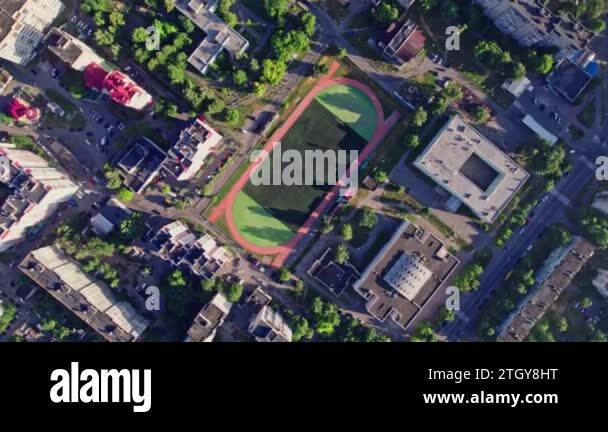 Buildings with street in small town with empty football soccer field ...
