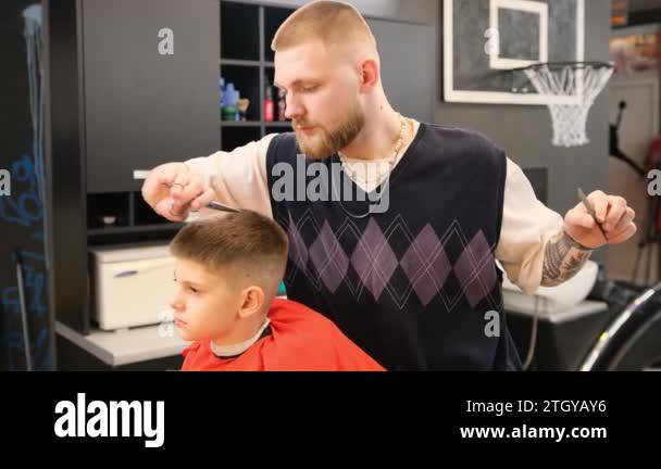 A teenage boy gets a haircut in a barber shop, a childs haircut with ...