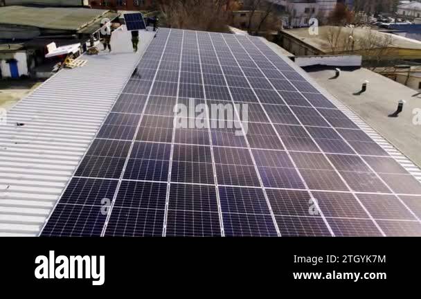 Modern solar panels produce clean electricity. Solar technician installing solar panels on house ...