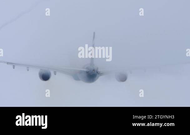Cinematic footage of a plane flies into a rainy dark cloud, rear view ...