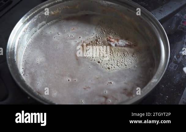 While boiling canola oil in a skillet, the cook puts breaded chicken ...