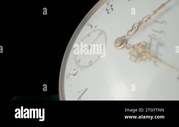 Antique pocket watch with a white dial and gold moving hands on black ...
