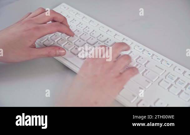 Womens hands type on a computer keyboard. White keyboard with black ...