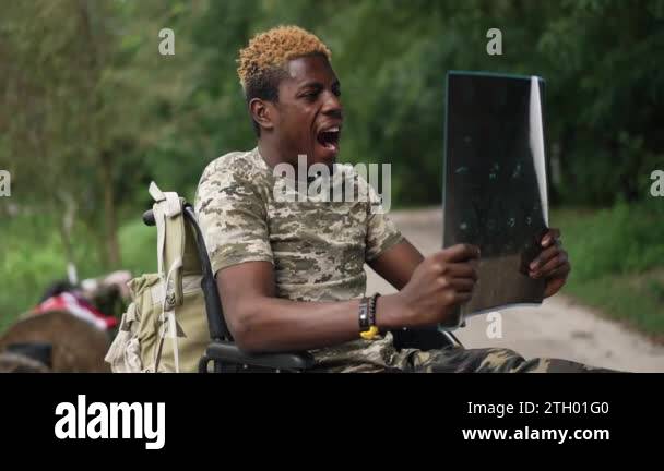 Devastated African American soldier in wheelchair screaming examining X ...