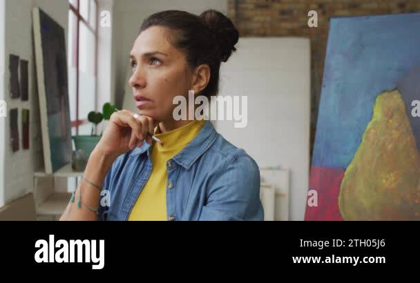 Video of thoughtful biracial female artist in studio. Art, crafts ...