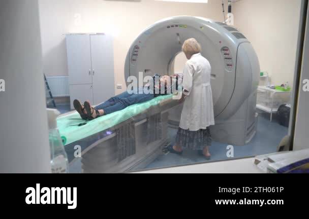 Young female patient lying on a ct or mri scan bed during medical exam ...