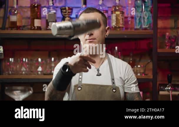 Slow motion video of a bartender throwing a shaker and mixing a ...
