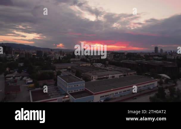 City landscape - sunset sky with beautiful red clouds above the city. Sunset with stunning night ...
