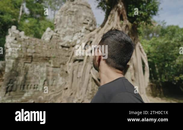 Male Tourist Gazing at The Khmer temple of Ta Som - Tree growing atop ...