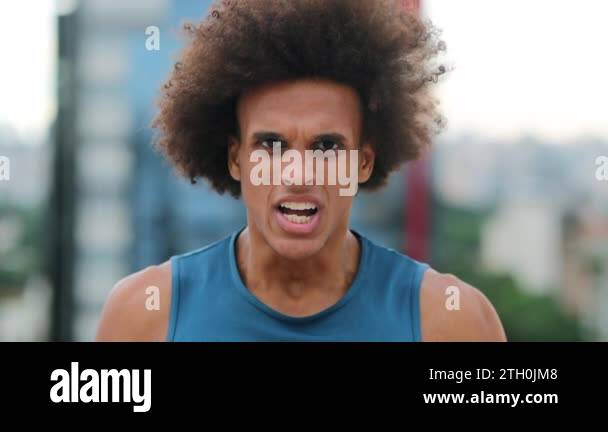 Angry african man screaming from the top of his lungs looking to camera ...