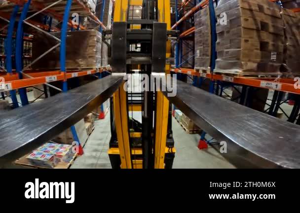 Forklift fork close-up. The load lifter rides on the warehouse pov ...