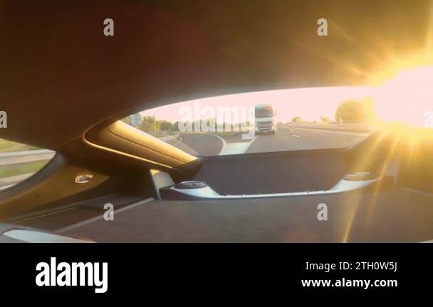 CLOSE UP, LENS FLARE: Golden sunbeams shine through rear window of car ...