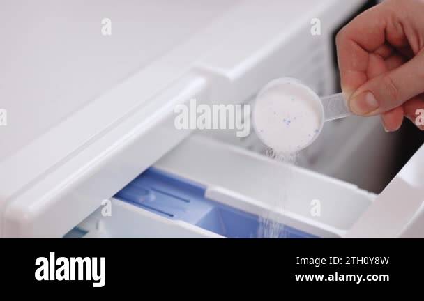 Woman carefully poured laundry detergent into compartment of washing ...