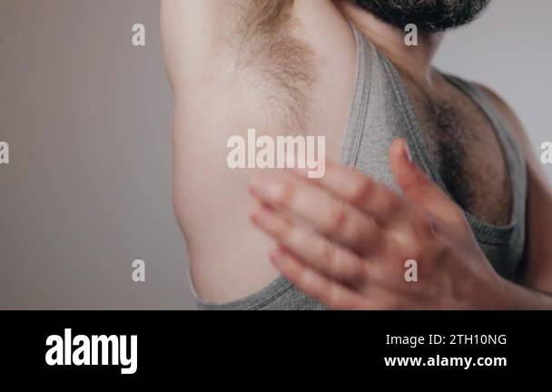 Close up slow motion shoot of sweaty and smelly from heat man touching ...