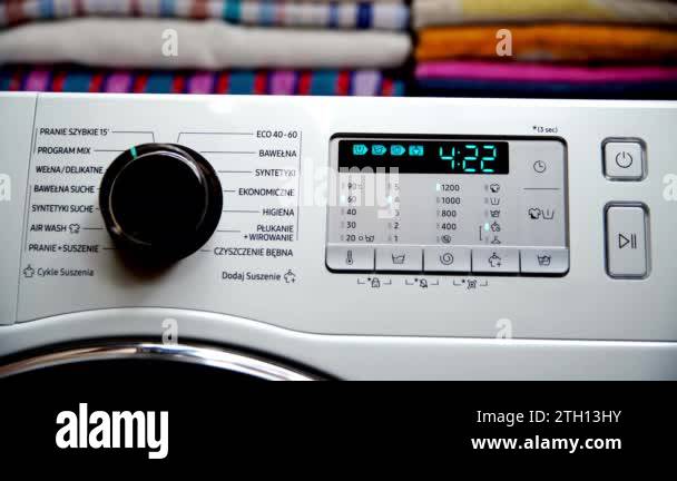 The man starts the laundry process by clicking on the start button and ...