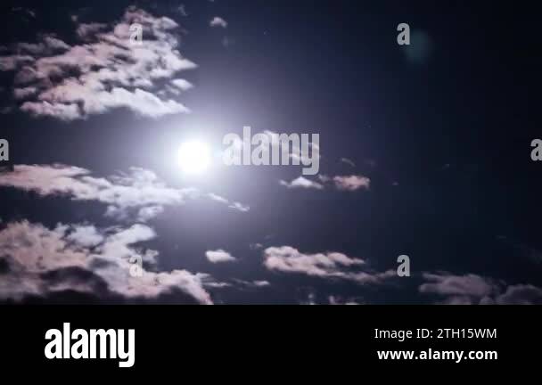 Full moon moves in the night sky through dark clouds, Timelapse. The ...