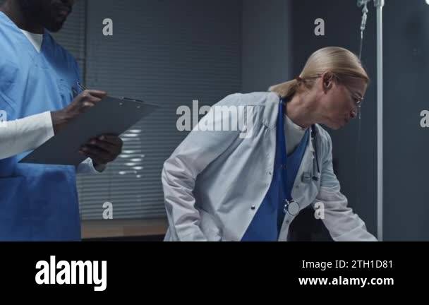 Tilting down of Caucasian female doctor and Black male nurse standing ...