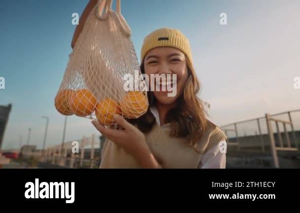 Young Gen Z woman asia people smile look at camera showing carry fruit ...