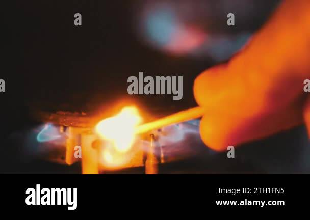 Ignite the gas on the stove with a match close-up in slow motion ...
