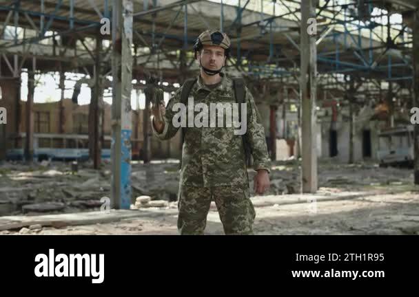 Portrait of strong and brave man posing on destroyed steel plant with ...