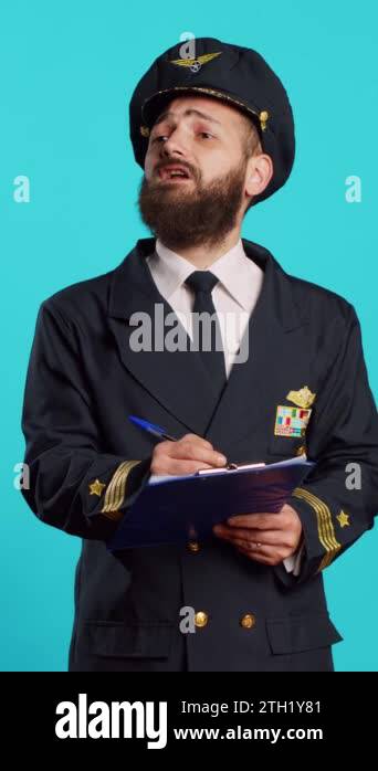 Vertical video: Confident aircrew captain checking list on papers ...