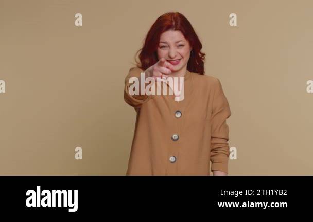 Amused redhead woman pointing finger to camera, laughing out loud ...