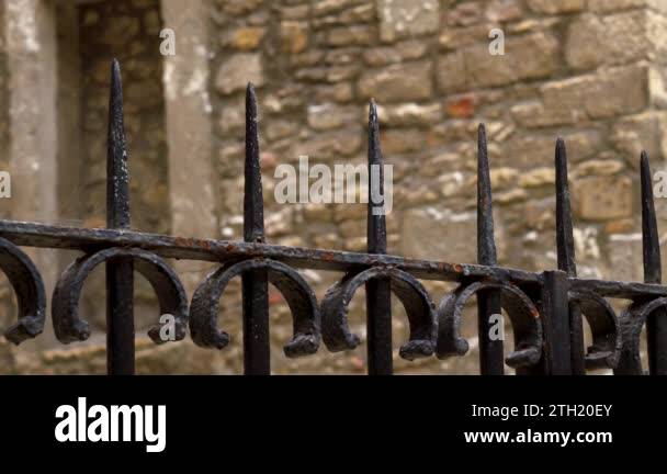 Black forged iron fence with spikes and peaks of an antique medieval ...