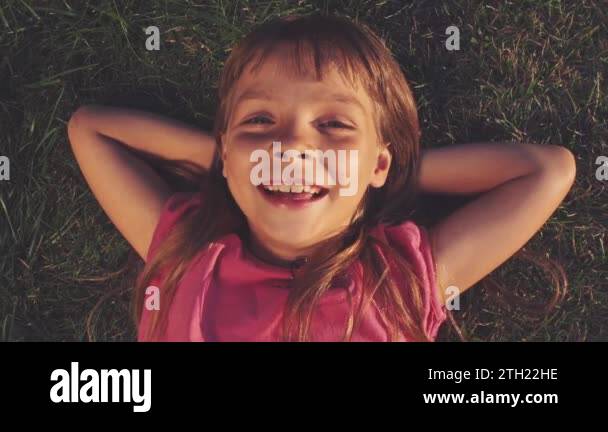 Little girl lying on grass Stock Video Footage - Alamy
