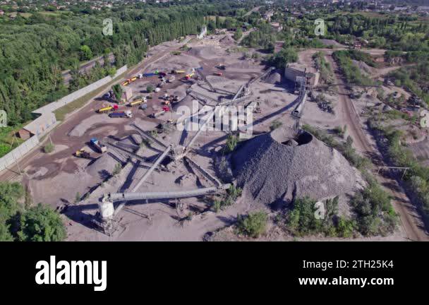 Excavator loading crushed stone into a dump truck in a crushed stone ...