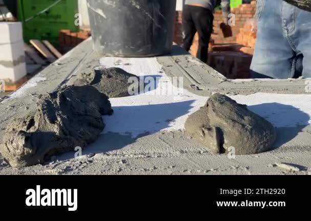 A male builder lays a foam block on a special mortar for laying blocks ...