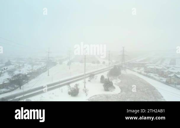 Transmission power tower with wires at winter snow storm. Electricity ...
