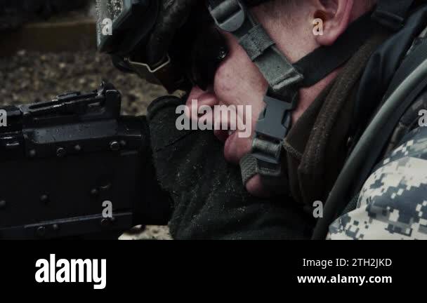 Close-up moving from a soldier's face to his hand pulling the trigger ...