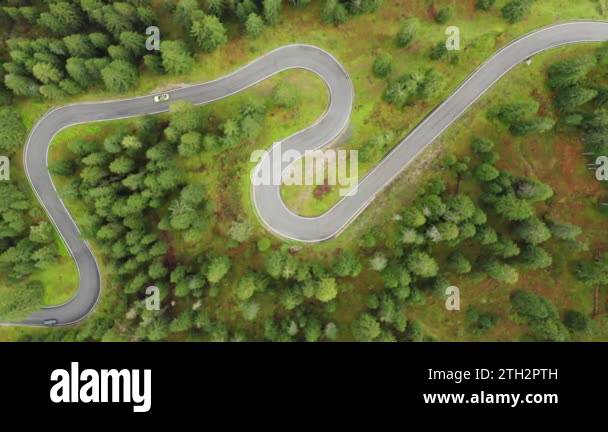 Cars on driveway of famous Snake Road surrounded by forests and meadows ...
