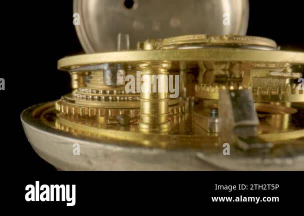 Inside view of a moving clockwork of golden mechanical clock on black ...