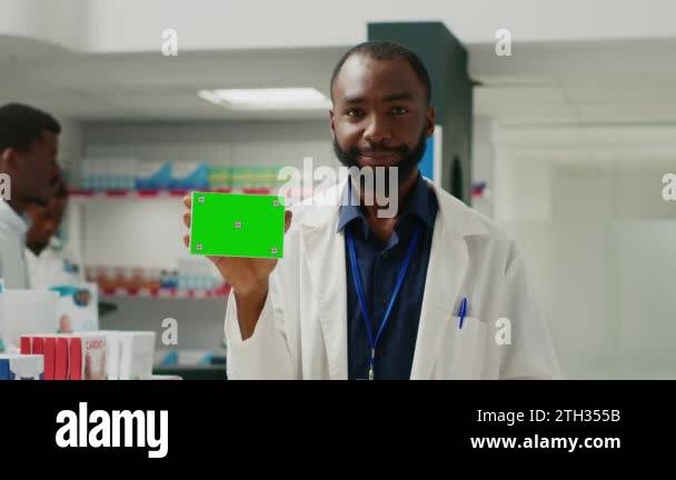 Pharmacy consultant holding greenscreen on box of drugs, showing blank ...