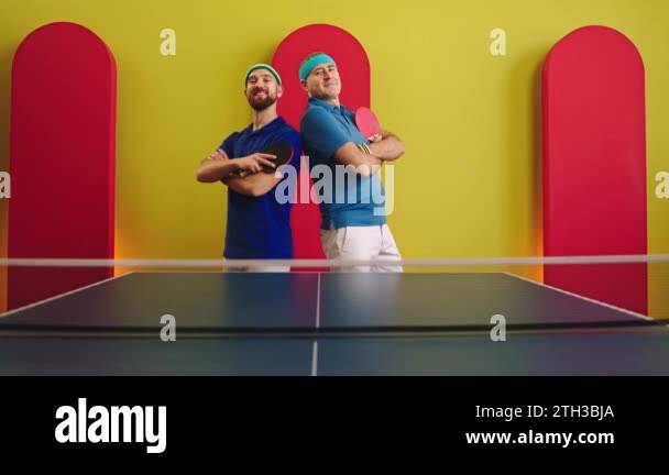 Smiling large two ping pong players getting excited after end to play ...