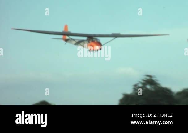 Vintage wooden glider landing on a grass airfield with flight ...