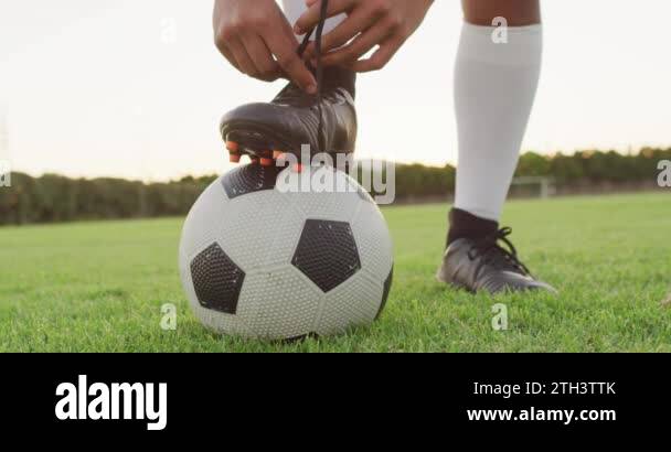 Video of biracial football player with ball tie the laces. Male ...