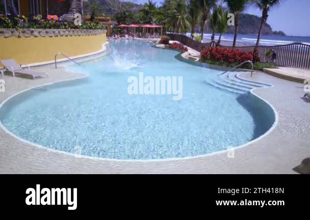 A satic shot of a man running and diving into a pool on the left side ...