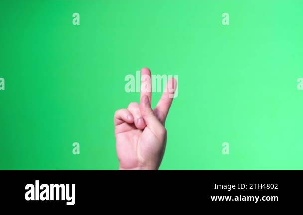 Gesture of victory by male hand, green background of color key screen ...