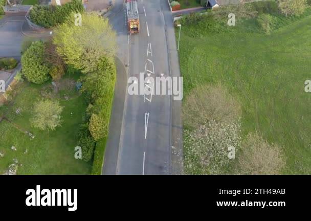A bin lorry, refuse collection vehicle makes it way up the road as men ...