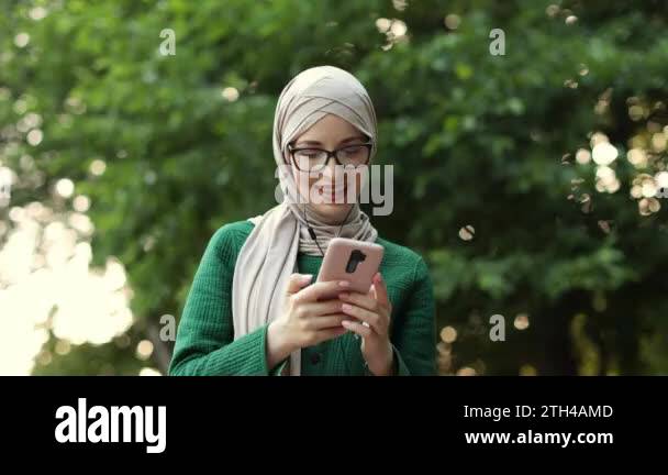 Music streaming platform concept. Joyful muslim girl in hijab wearing ...