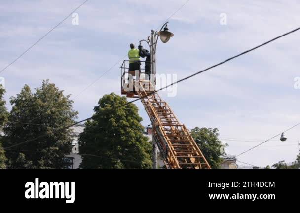 Technician on aerial, fix light, repair works. Street light repair work ...